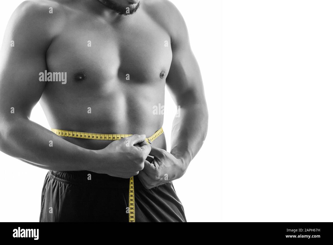 Young muscular shirtless man with beard measuring waist circumference ...
