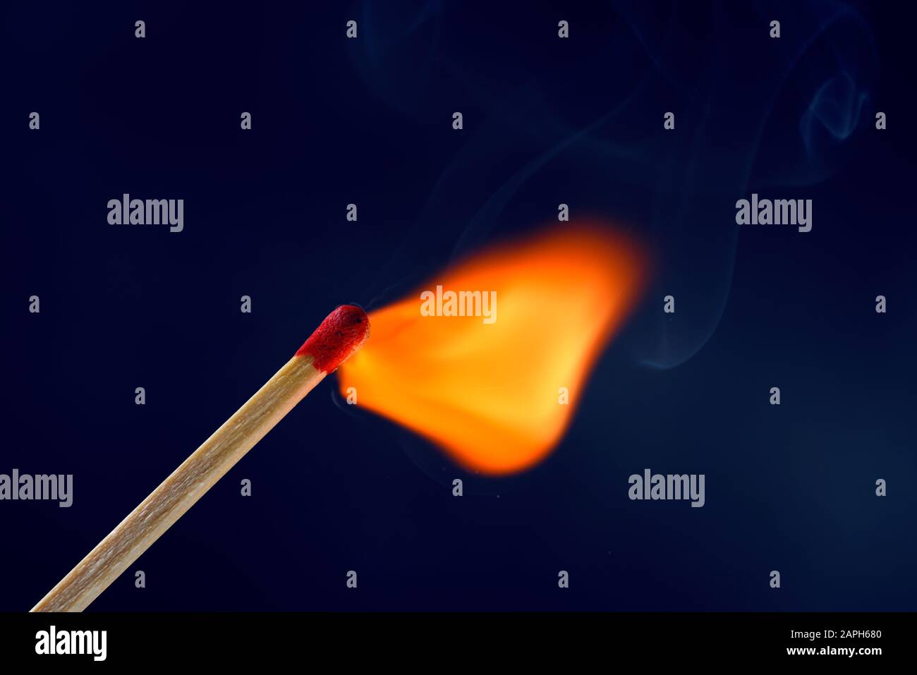 Match stick ignited burning bright big fire flame with blue smoke on ...