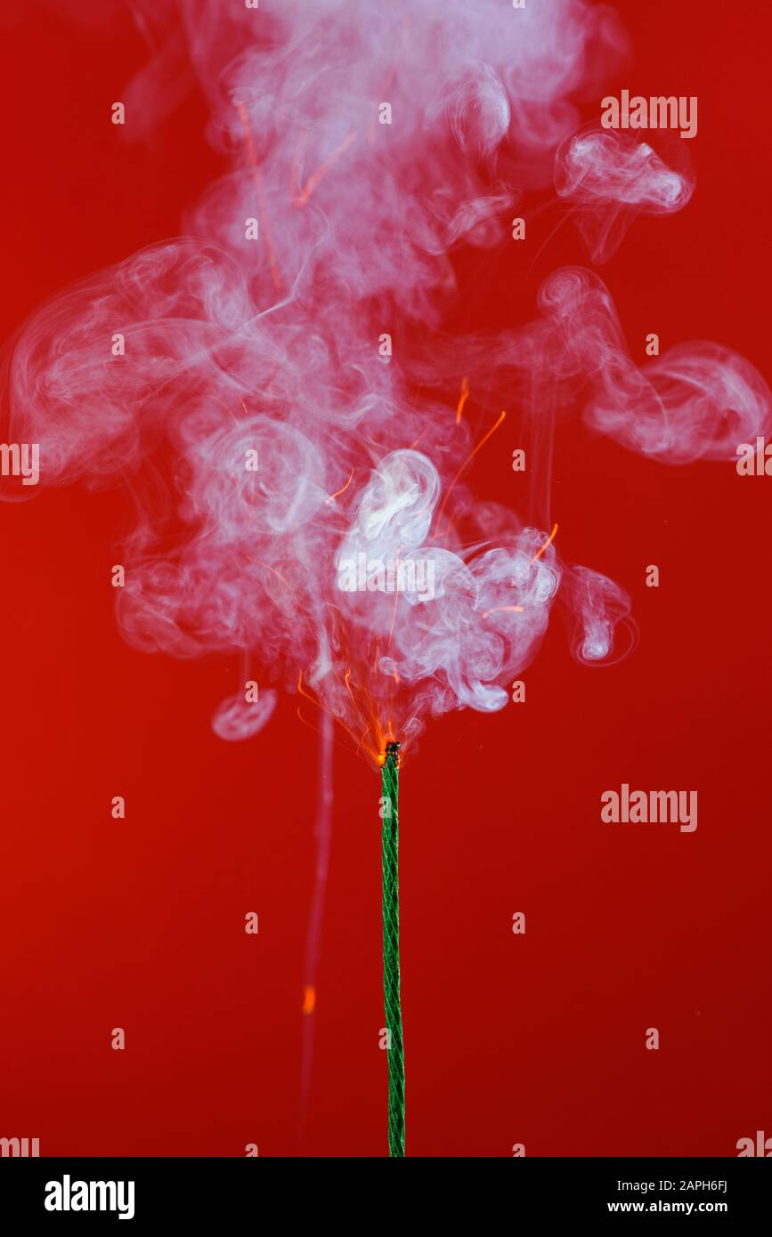 Burning fuse wick with sparks and smoke on red background Stock Photo ...