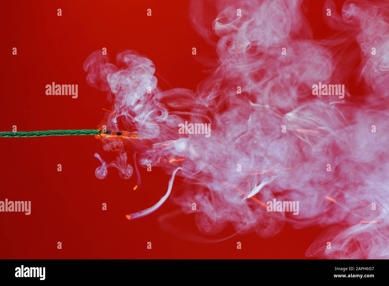 Burning fuse wick cord with sparks and smoke on red background Stock ...