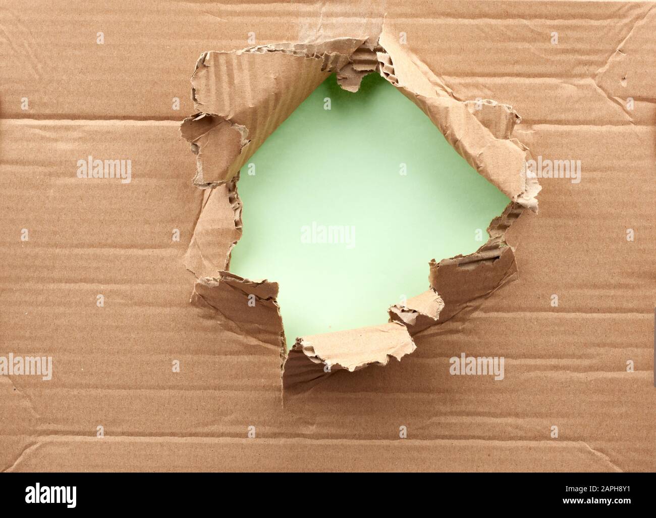hole in brown cardboard paper with torn and curved edges. Blank ...