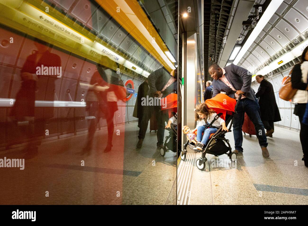 A man boards a Jubilee line train at Westminster with his buggy Stock ...