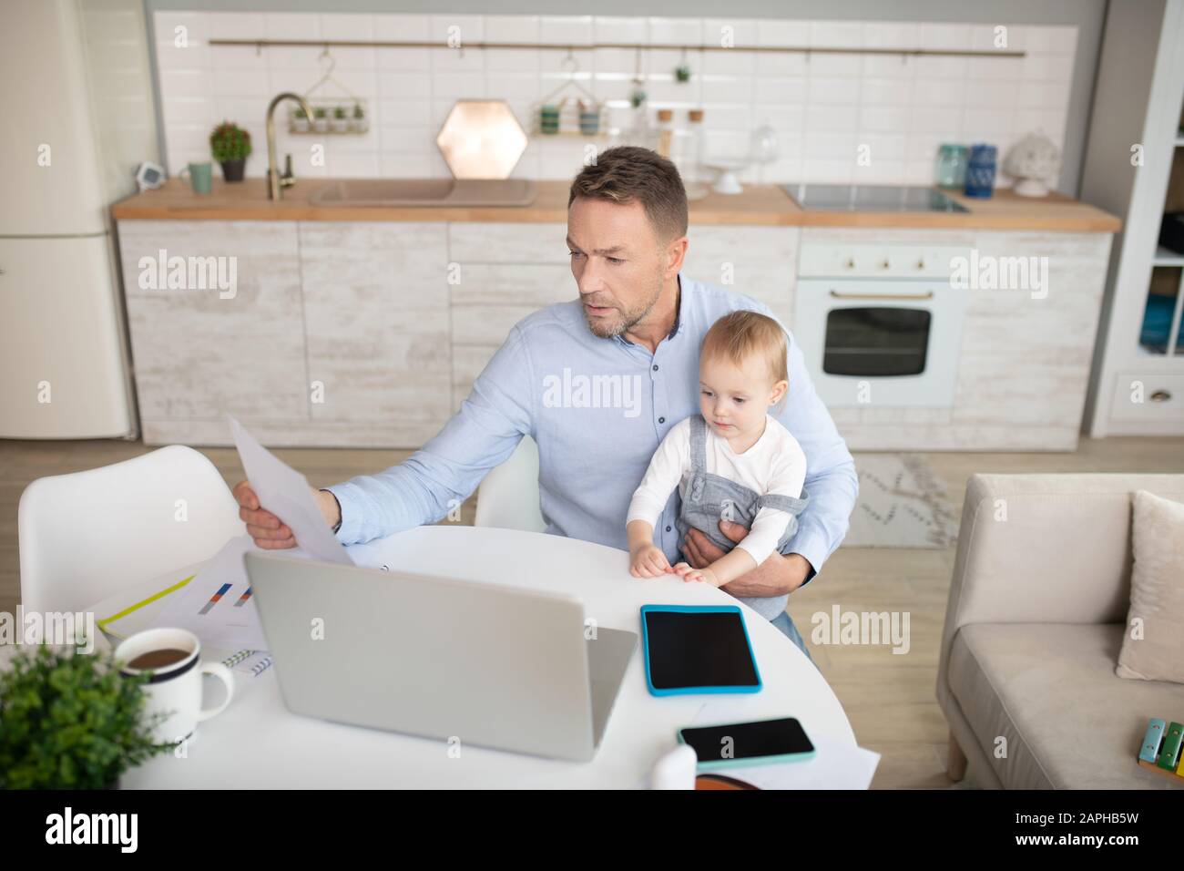 Man in a blue shirt looking concentrated while watching video on the ...