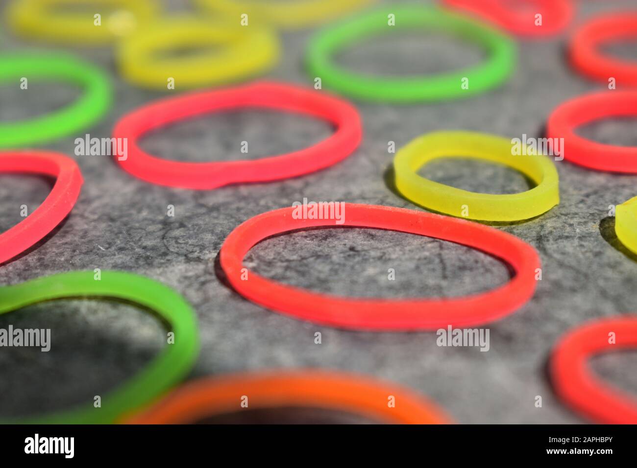 Colorful rubber bands in black background Stock Photo - Alamy
