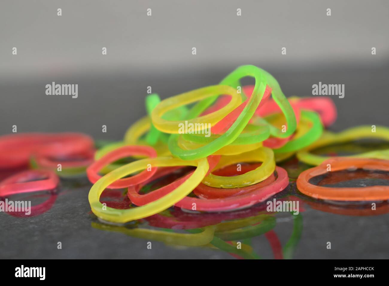 Colorful rubber bands in black background Stock Photo - Alamy