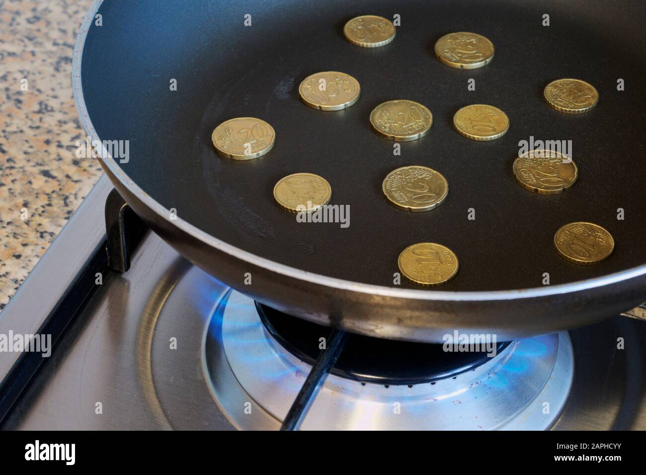 euro coins in a frying pan on gas stove Stock Photo - Alamy