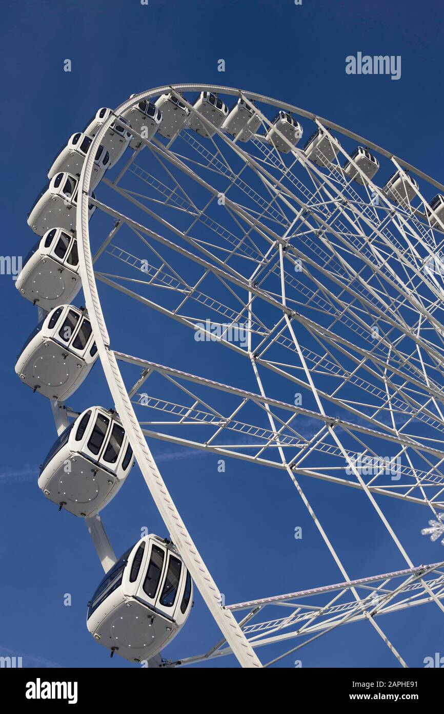 White ferris wheel against blue sky at a fairground. portrait ...