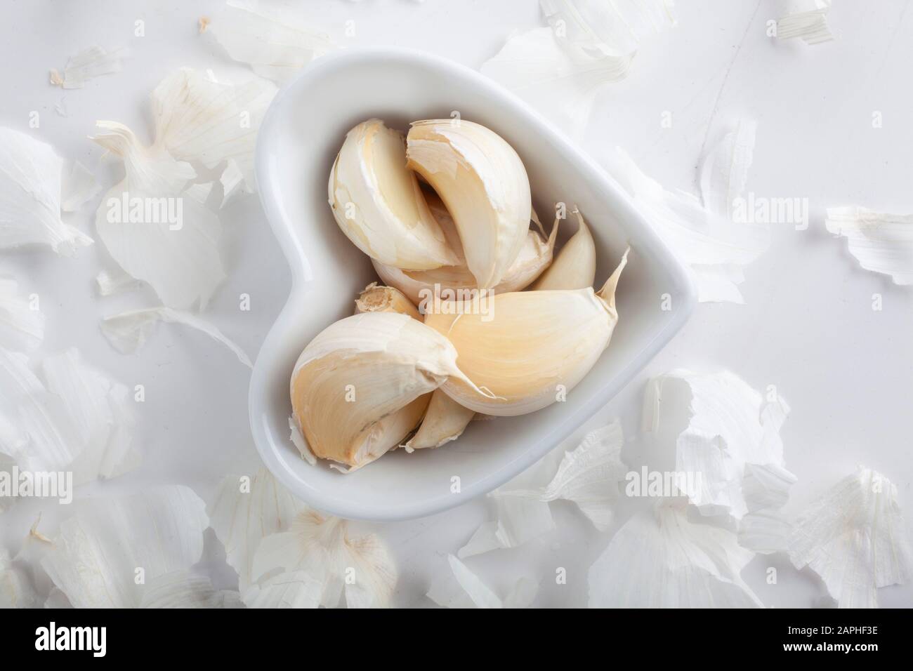 studio shot of individual pods of garlic in a heart-shaped bowl on ...