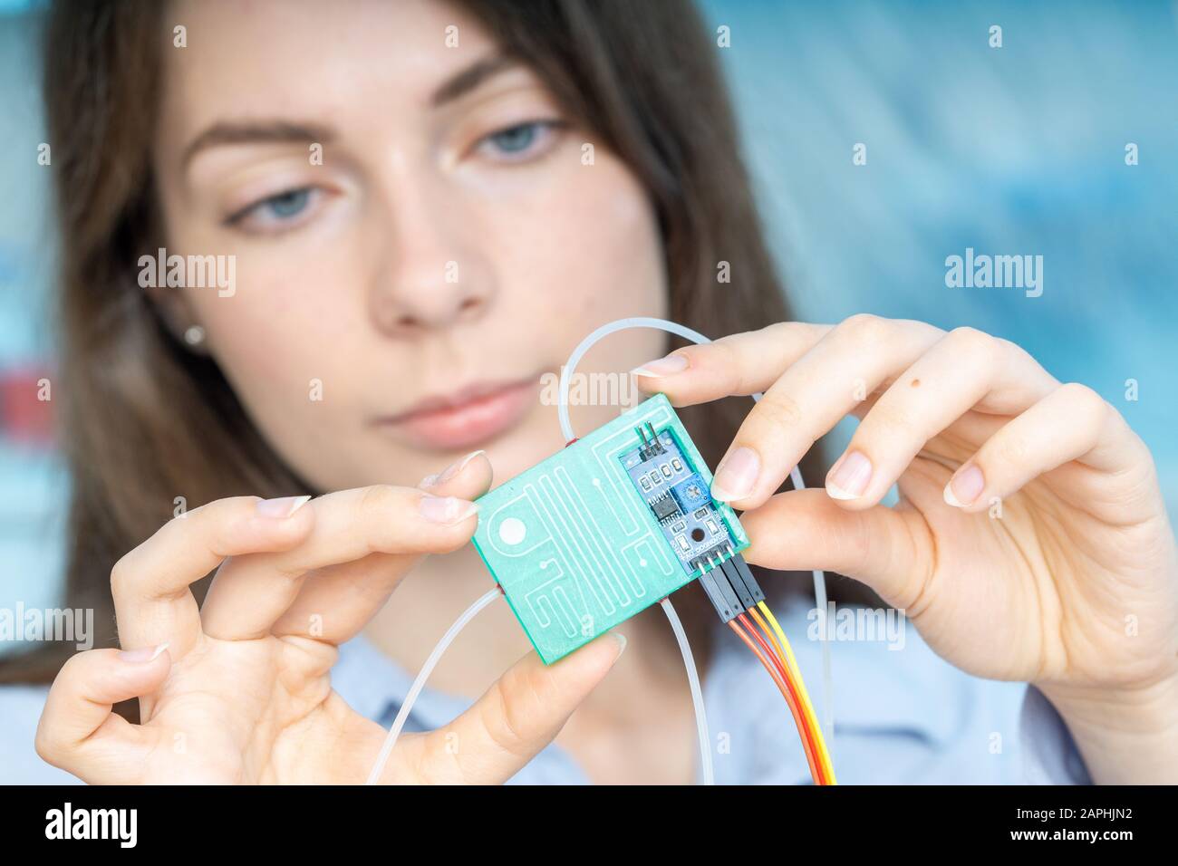 Young scientist woman in microbiological lab with lab-on-chip LOC ...