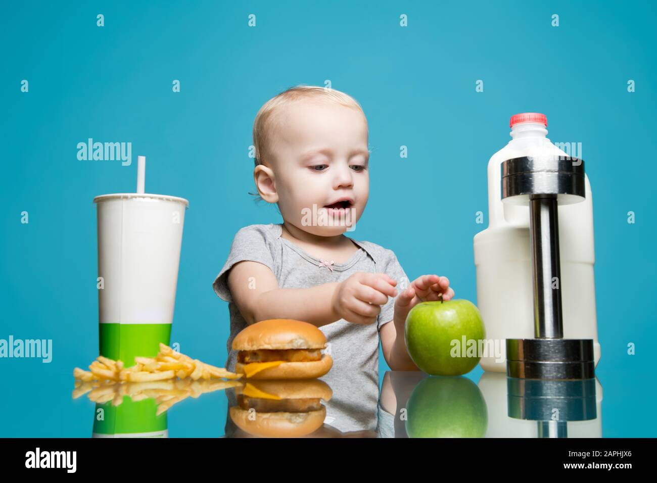 a little girl chose healthy food instead of harmful and grabs an apple ...