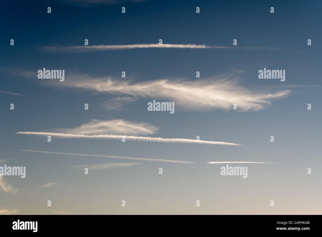 Sky with jet trails and sirrus cloud Stock Photo - Alamy