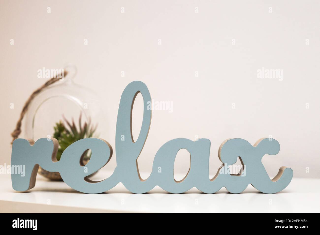 Wooden word Relax and plant in pot, home details, on wooden table ...