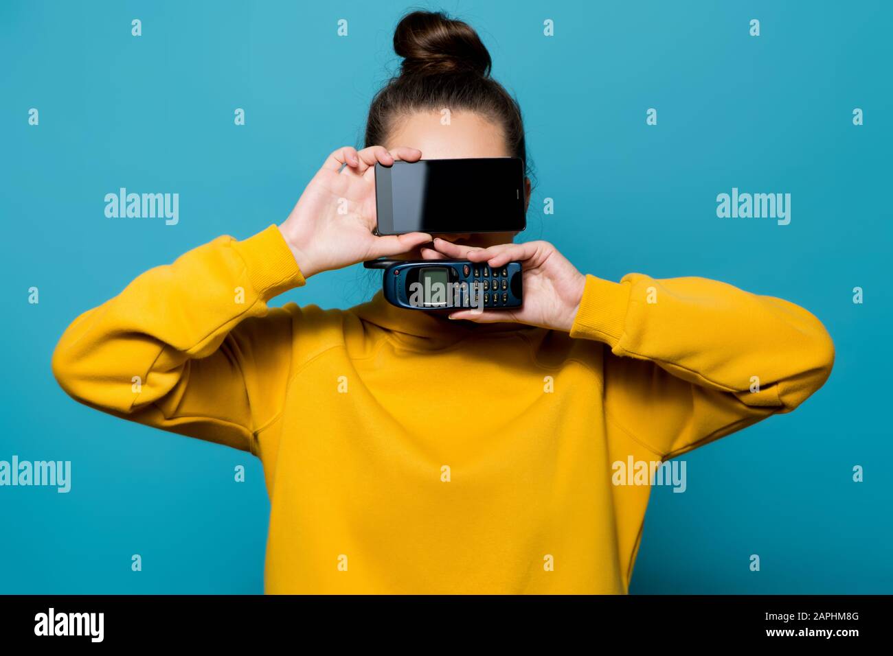 portrait of a young woman, she covers her face with old and new model ...
