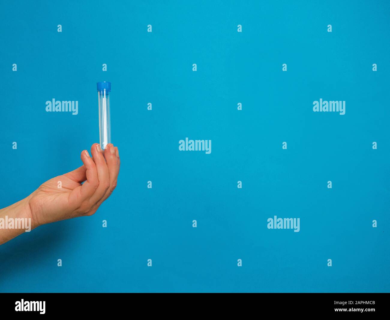 Hand with analysis tube on blue background with copy space Stock Photo ...