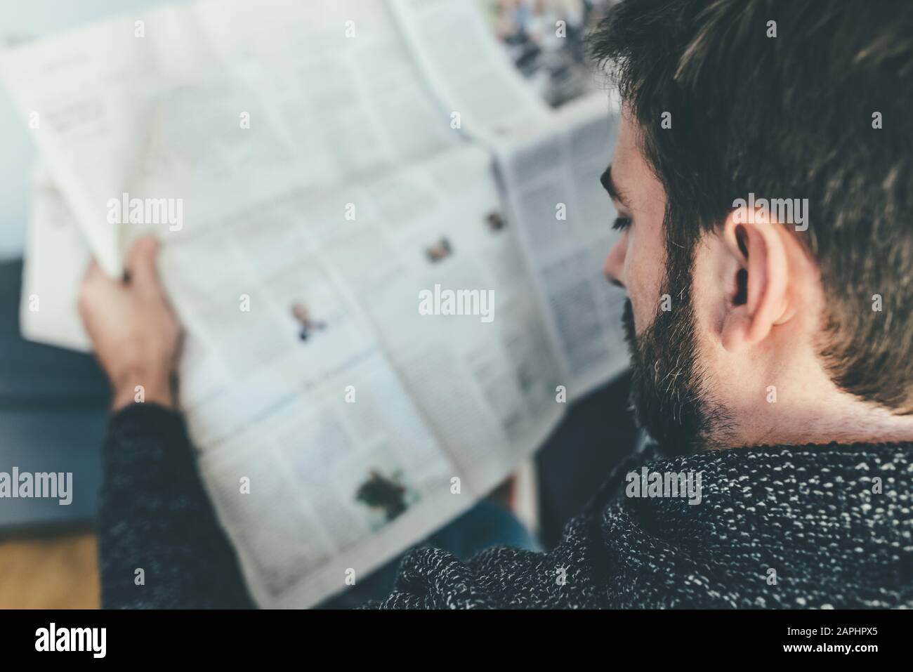 rear view of man reading newspaper while relaxing on couch Stock Photo ...