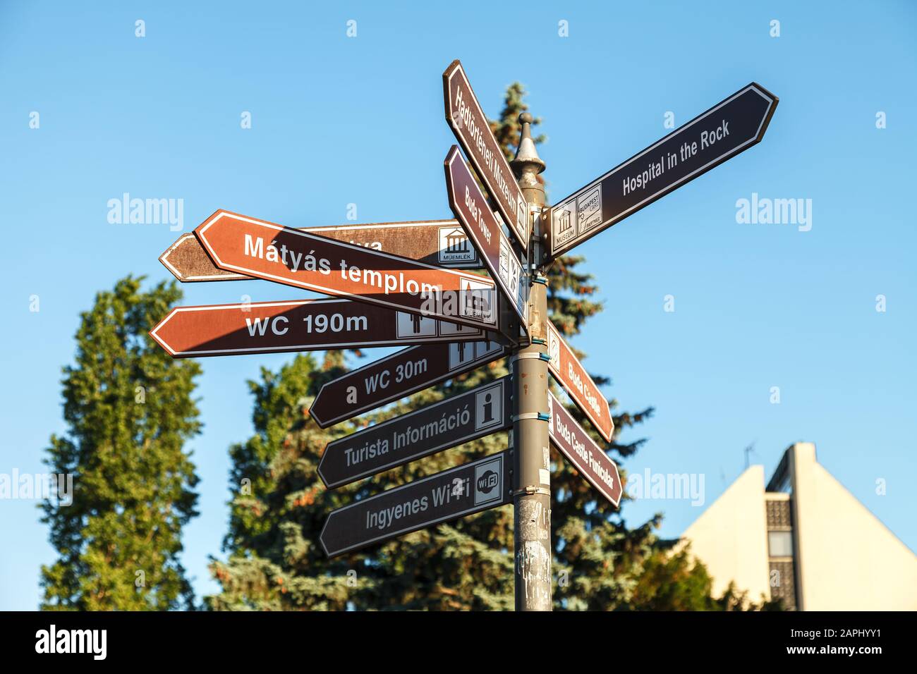 A metal pole with signage plates on which the name and distance to the ...