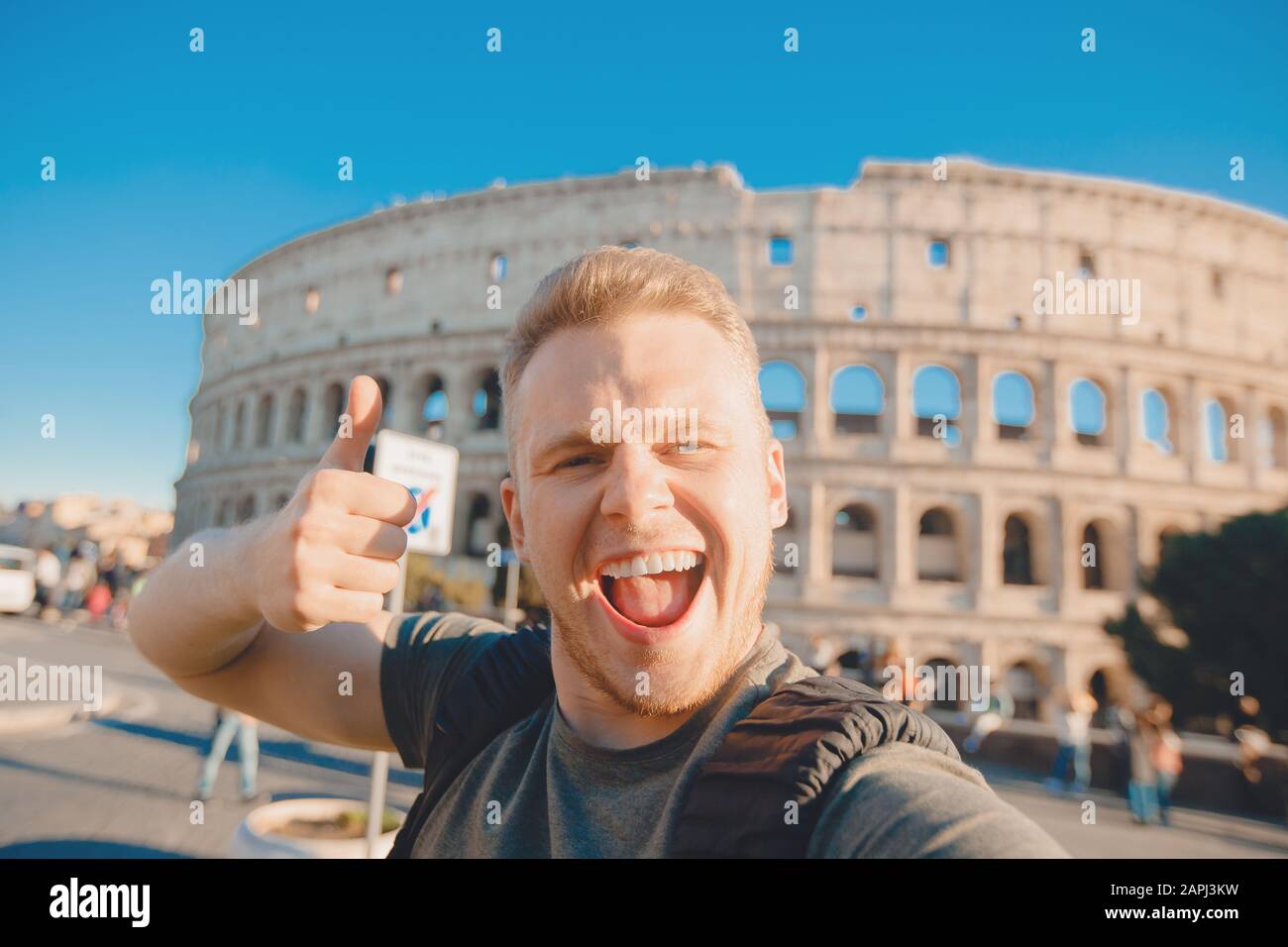 Happy young man making selfie in front of Colosseum in Rome, Italy ...