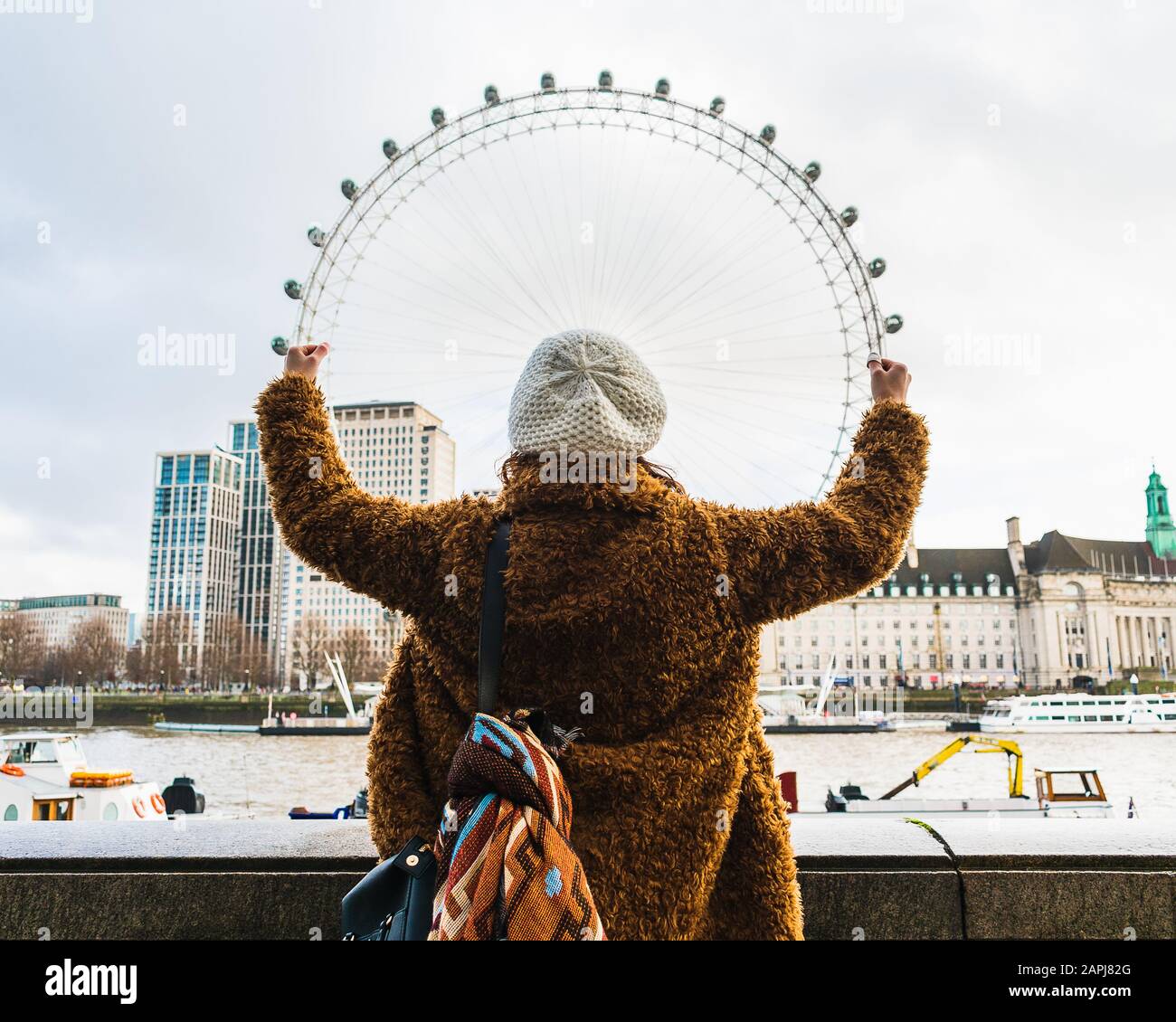 Young woman on her back holding the London Eye, one of the most famous ...
