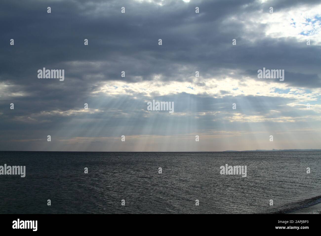 Sun rays beaming through picturesque clouds above the sea. Sun, clouds ...