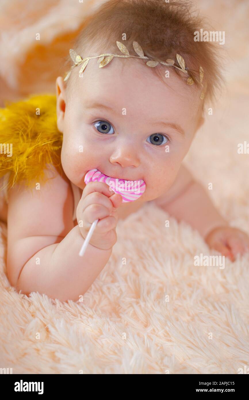 Little baby, angel in roses on a beige background Stock Photo - Alamy