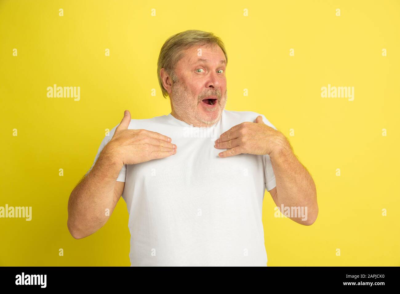 Calling, showing on himself. Caucasian man portrait isolated on yellow ...