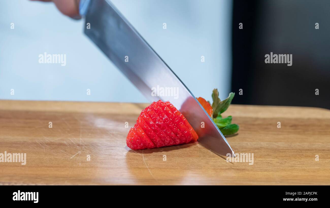 A fresh strawberry being cut into slices Stock Photo - Alamy