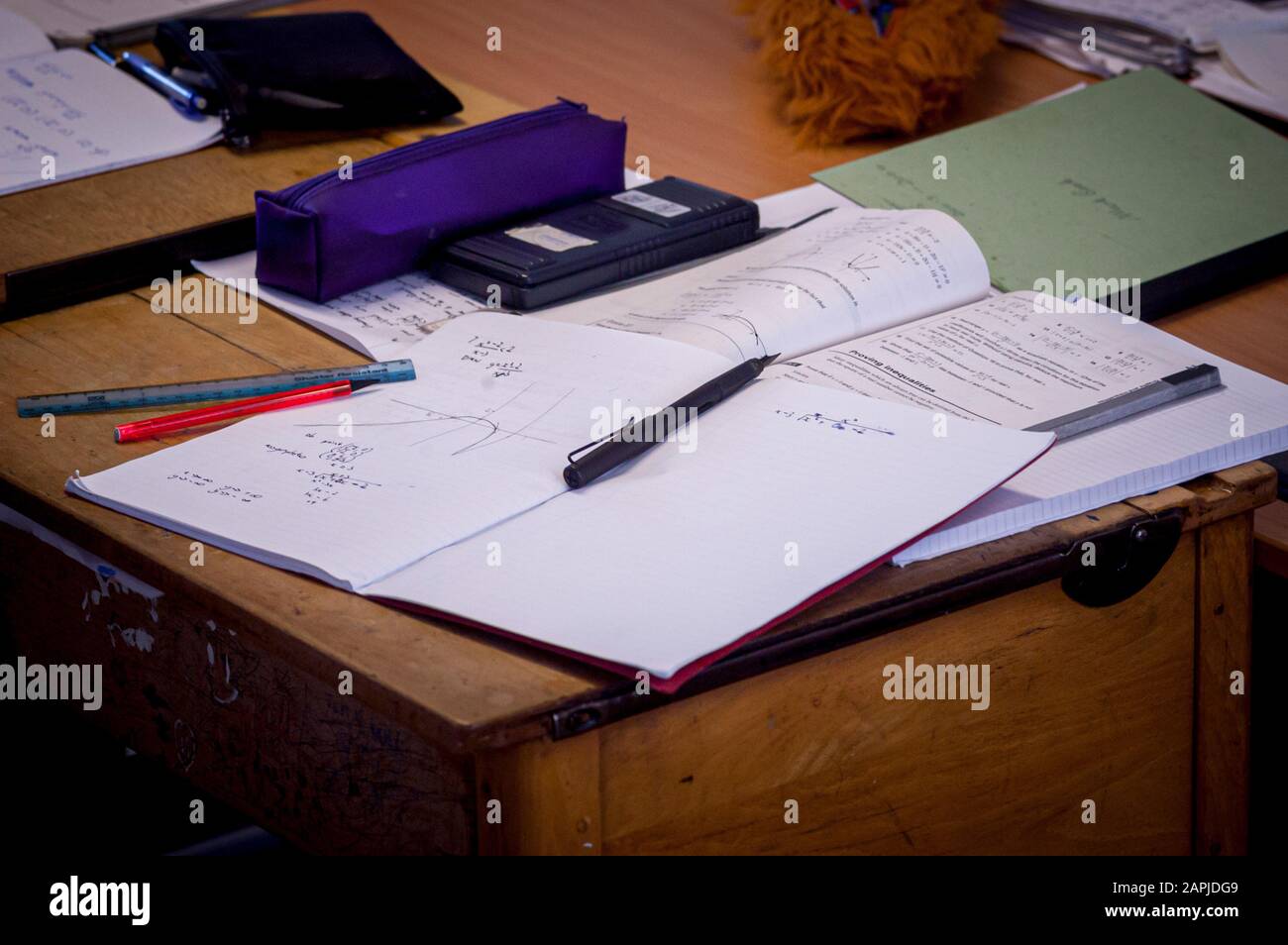 Books pen and calculator on desk in classroom Stock Photo - Alamy