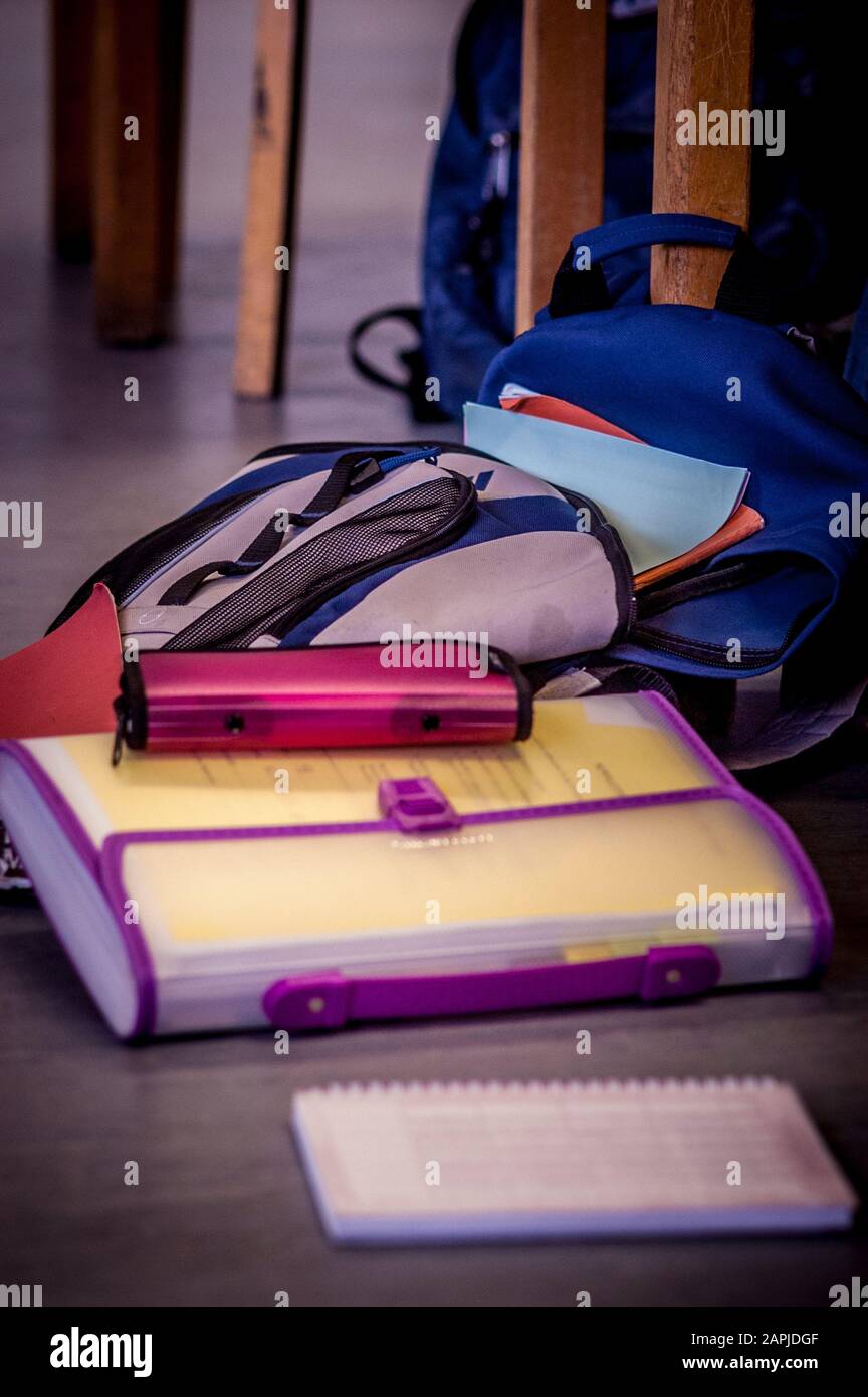 Pupils rucksack and school books on floor next to desk in classroom ...