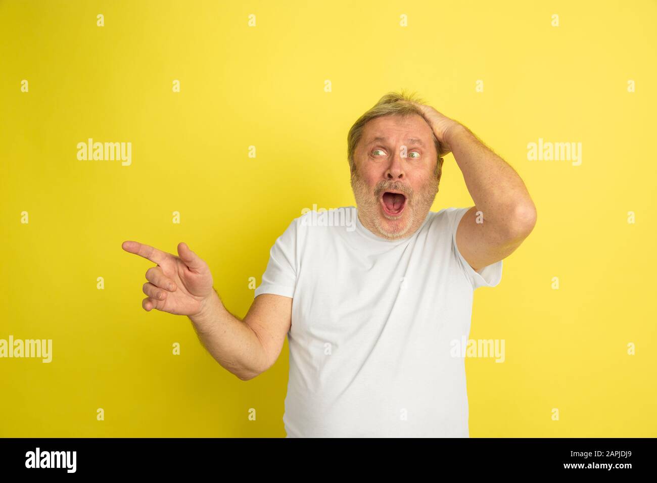 Astonished, shocked, pointing at side. Caucasian man portrait isolated ...