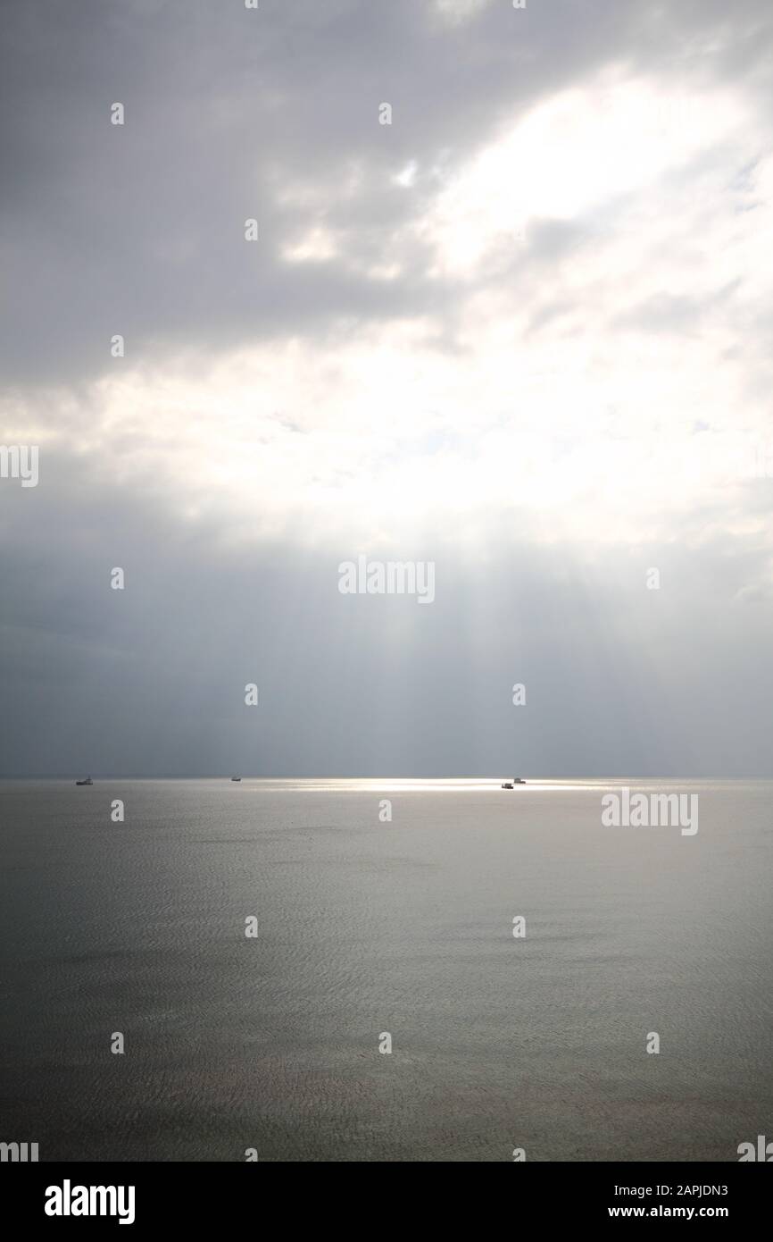 Sun rays beaming through picturesque clouds above the sea. Sun, clouds ...