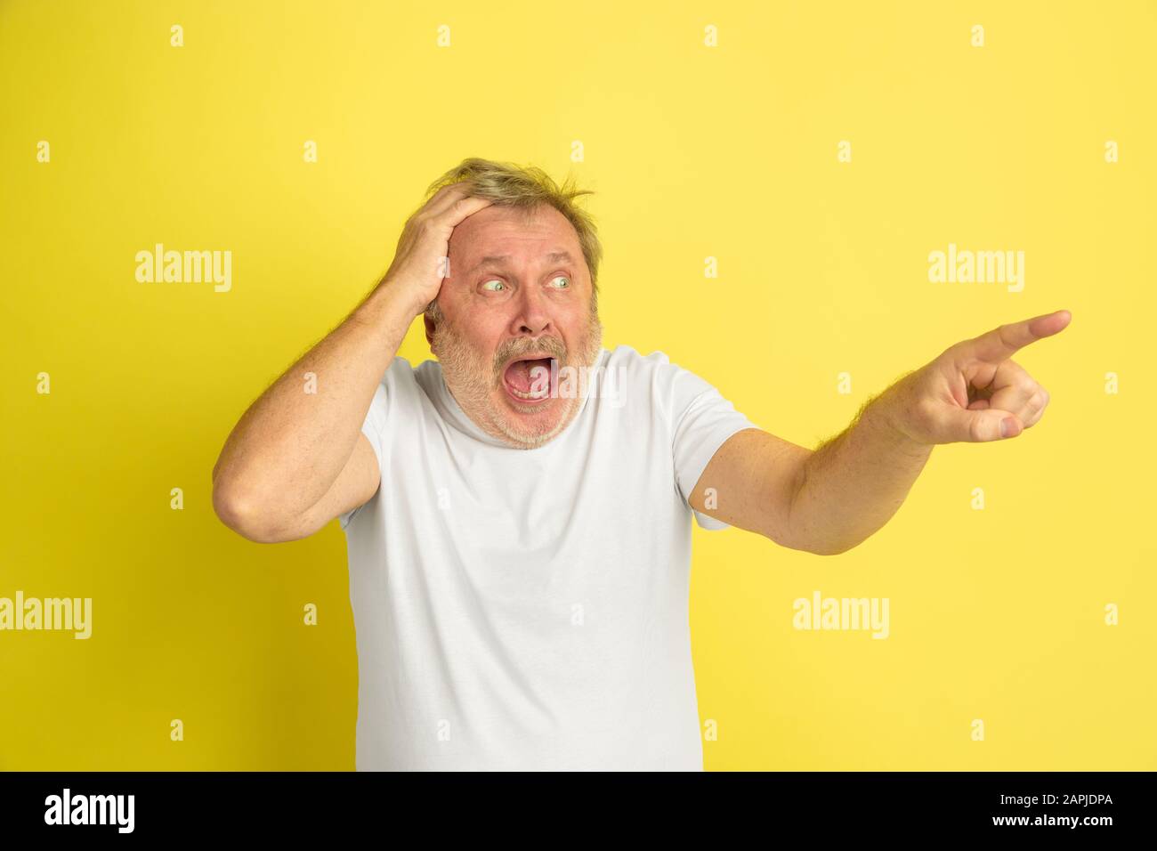 Astonished, shocked, pointing at side. Caucasian man portrait isolated ...