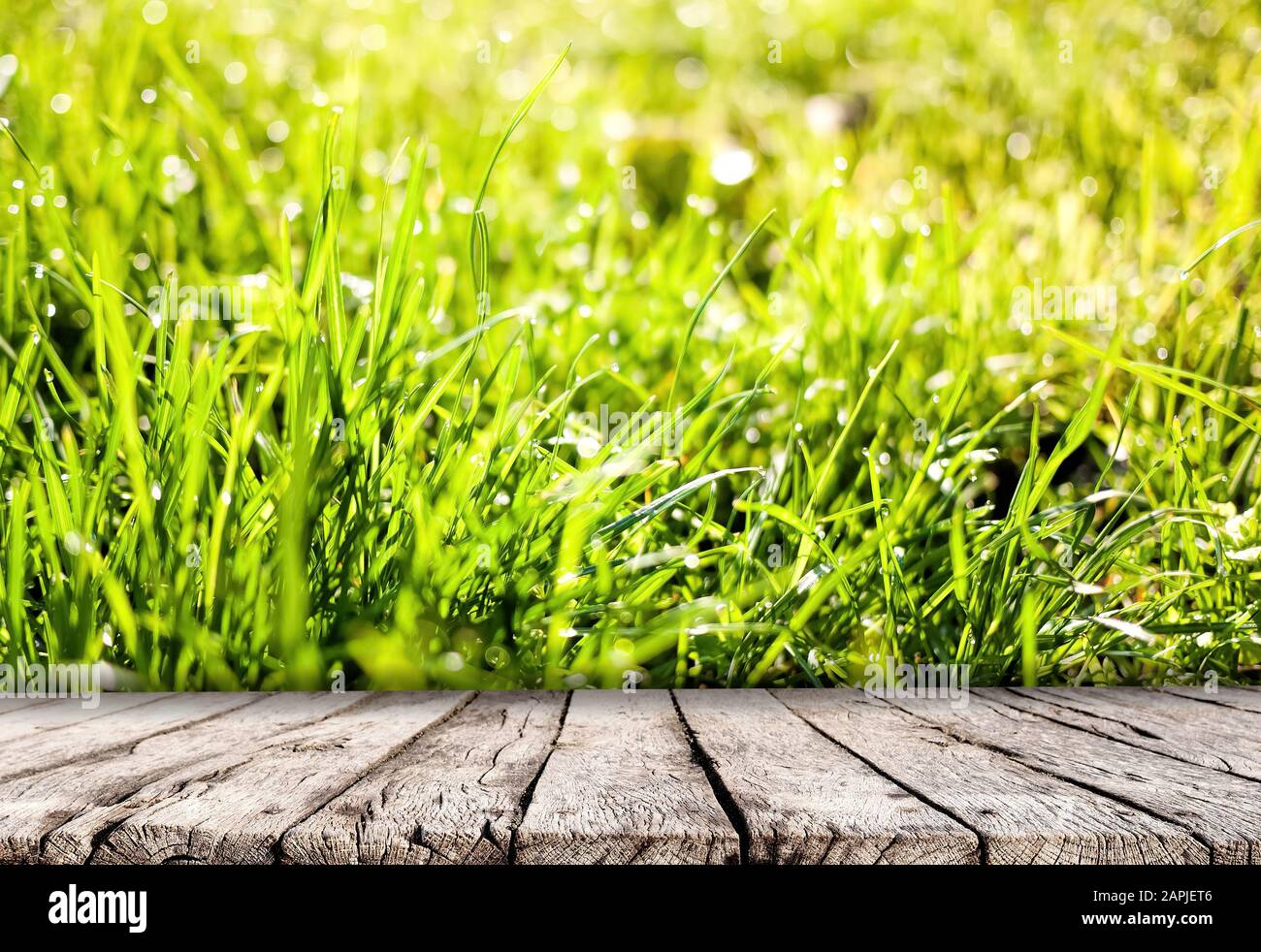 Wooden table top and spring grass nature background Stock Photo - Alamy