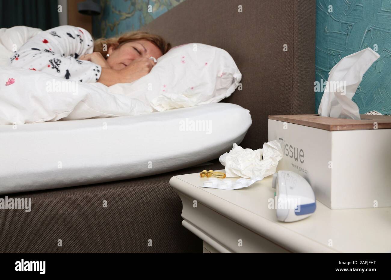 A woman is lying in bed with flu during a flu epidemic Stock Photo - Alamy