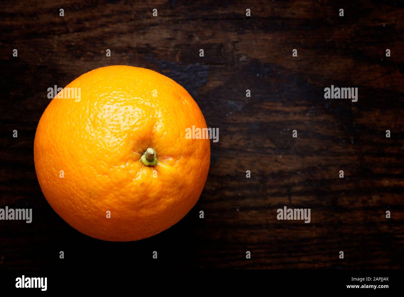 Single orange on dark background with copy space Stock Photo - Alamy
