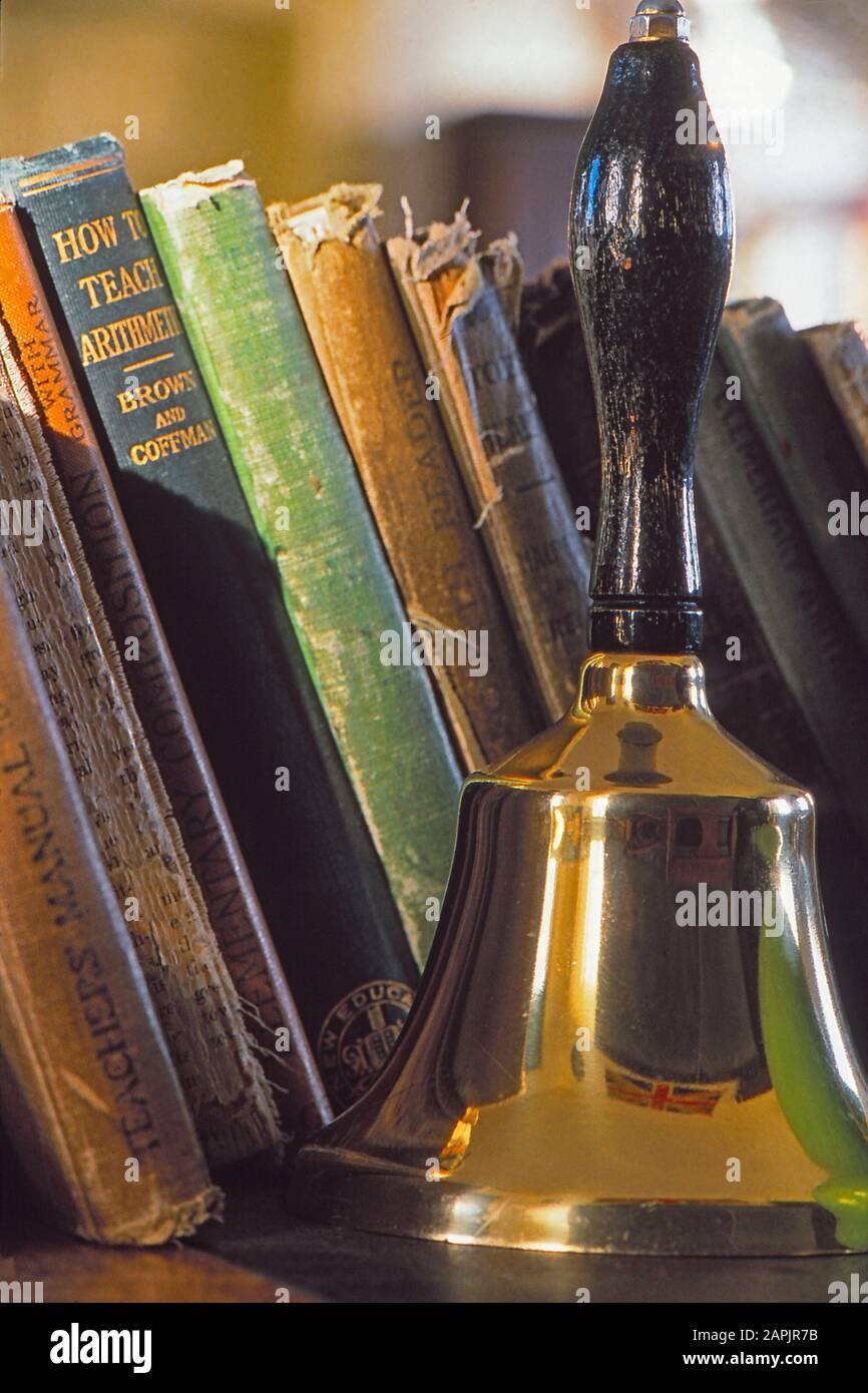 Vintage schoolhouse with books and a hand bell (handbell Stock Photo ...
