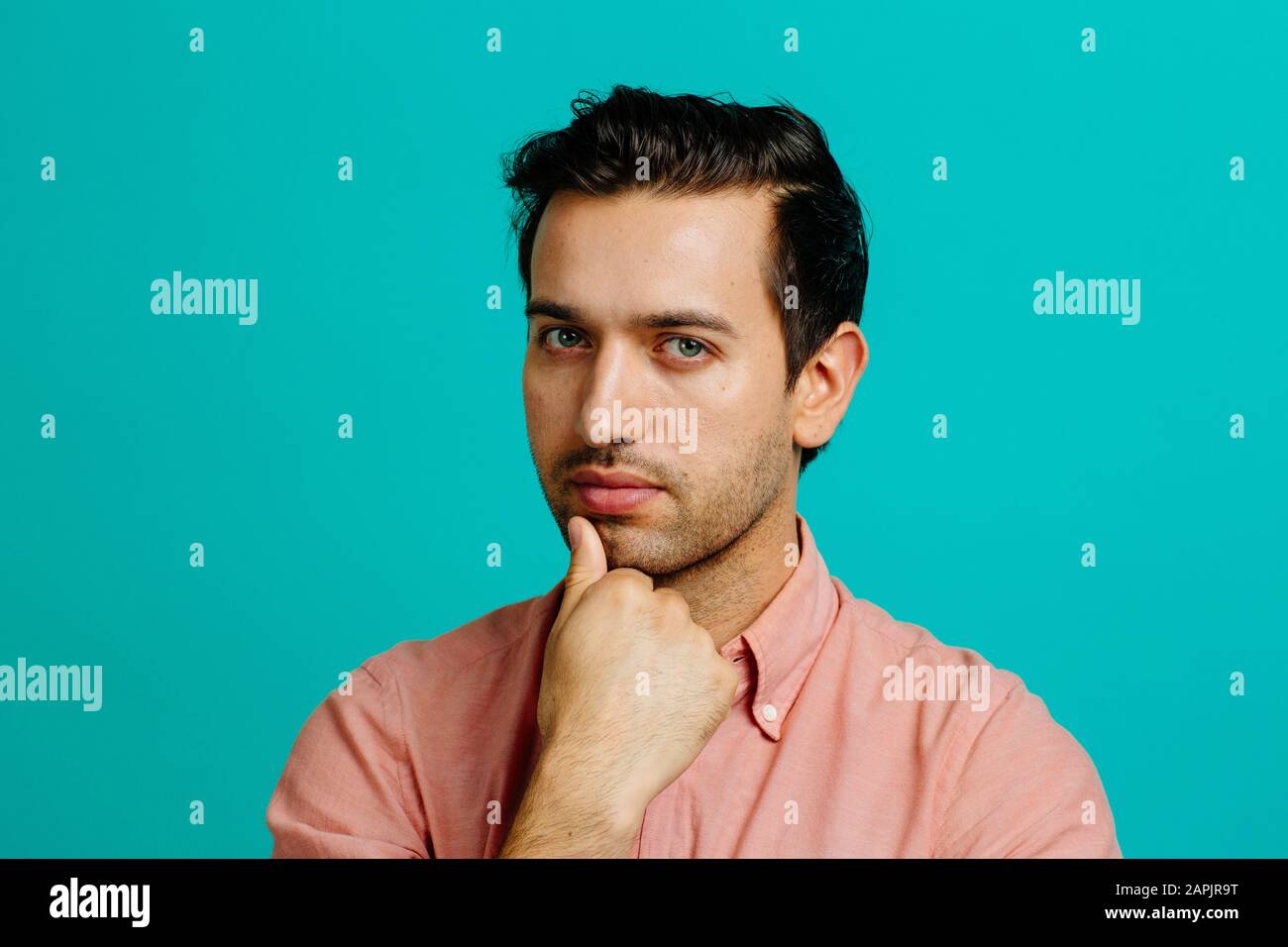 Portrait of a young adult man smiling, isolated on blue studio ...