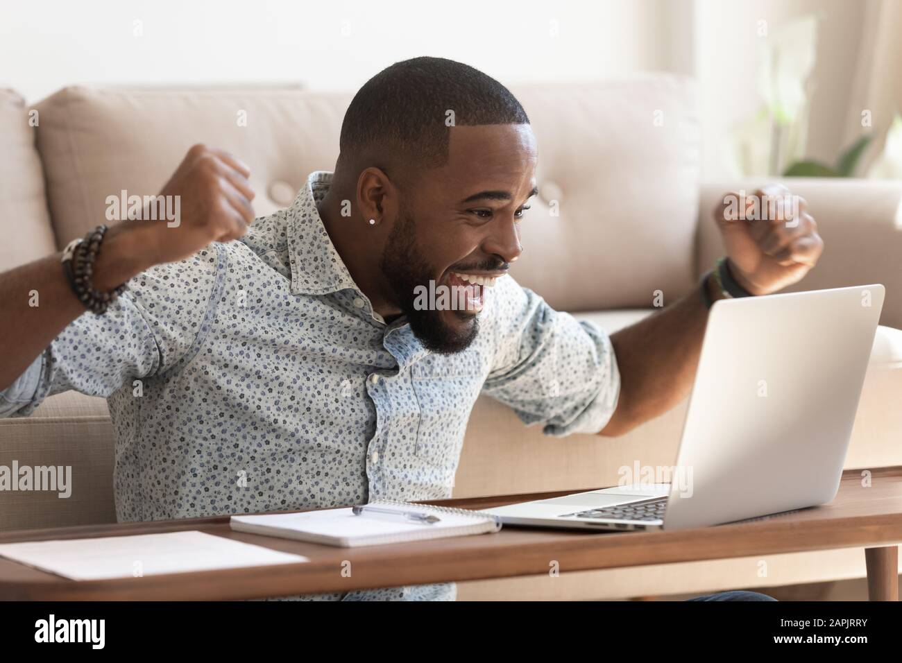 Excited african man read message on computer celebrating received ...