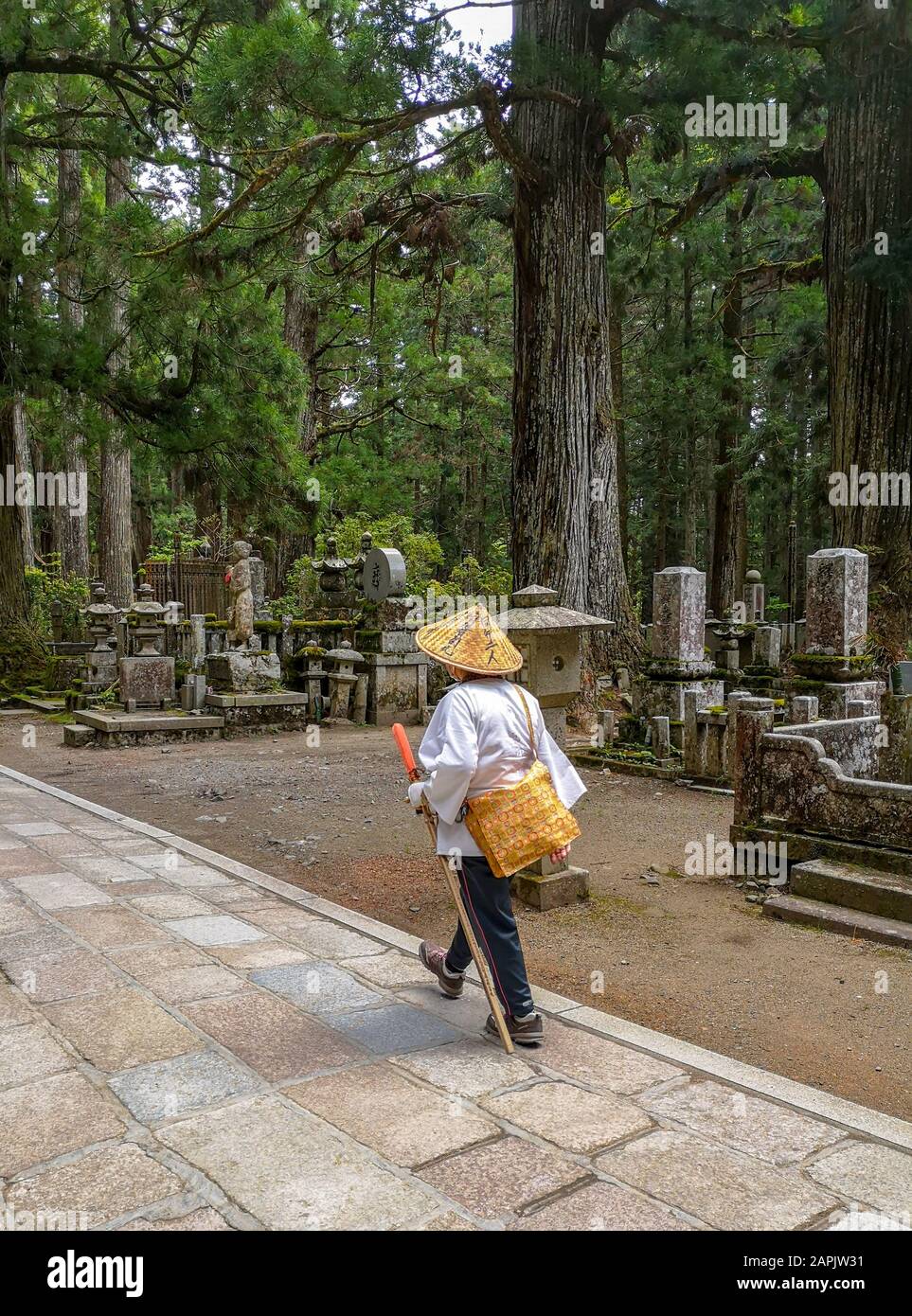 Pilgrim walking on the long path in the Okunion cemetery towards the ...