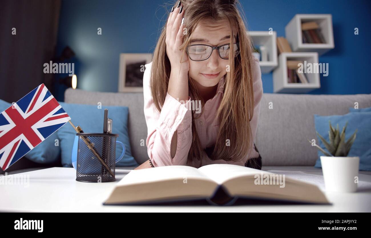 Puzzled girl reading book Stock Photo - Alamy