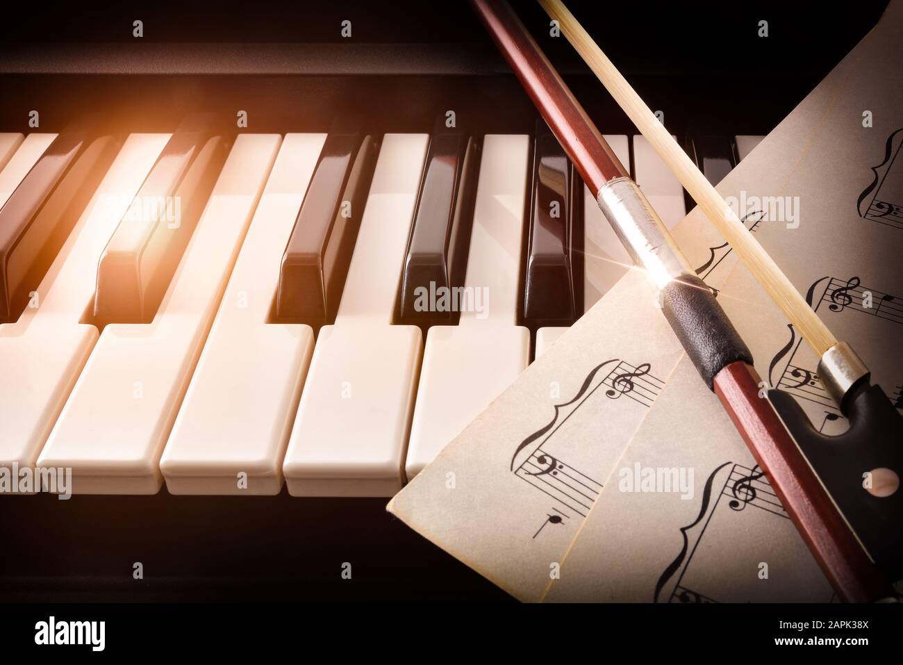 Bow with sheet music on piano keys top. Concept of interpretation of ...