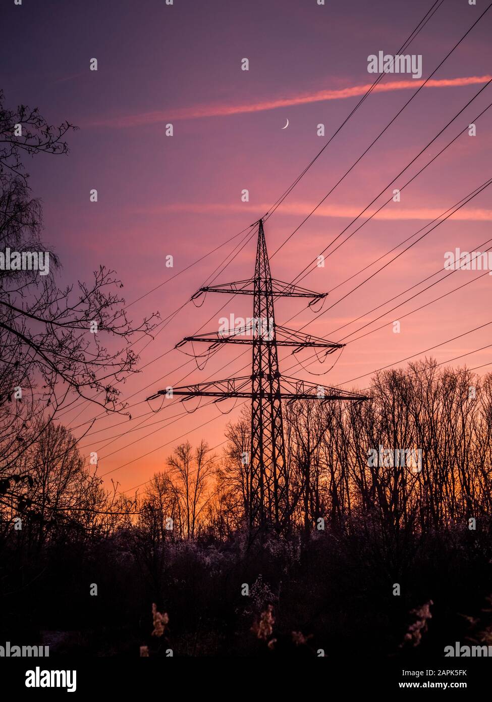 Silhouette of poles and power lines in the sunset Stock Photo - Alamy