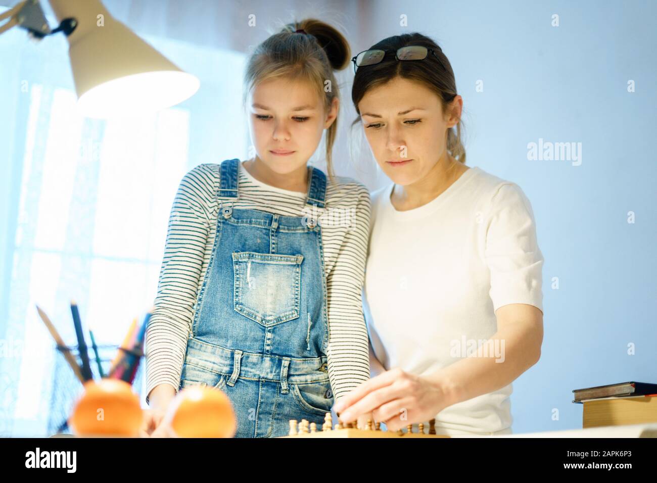 Mother and child are playing chess while spending time together Stock ...