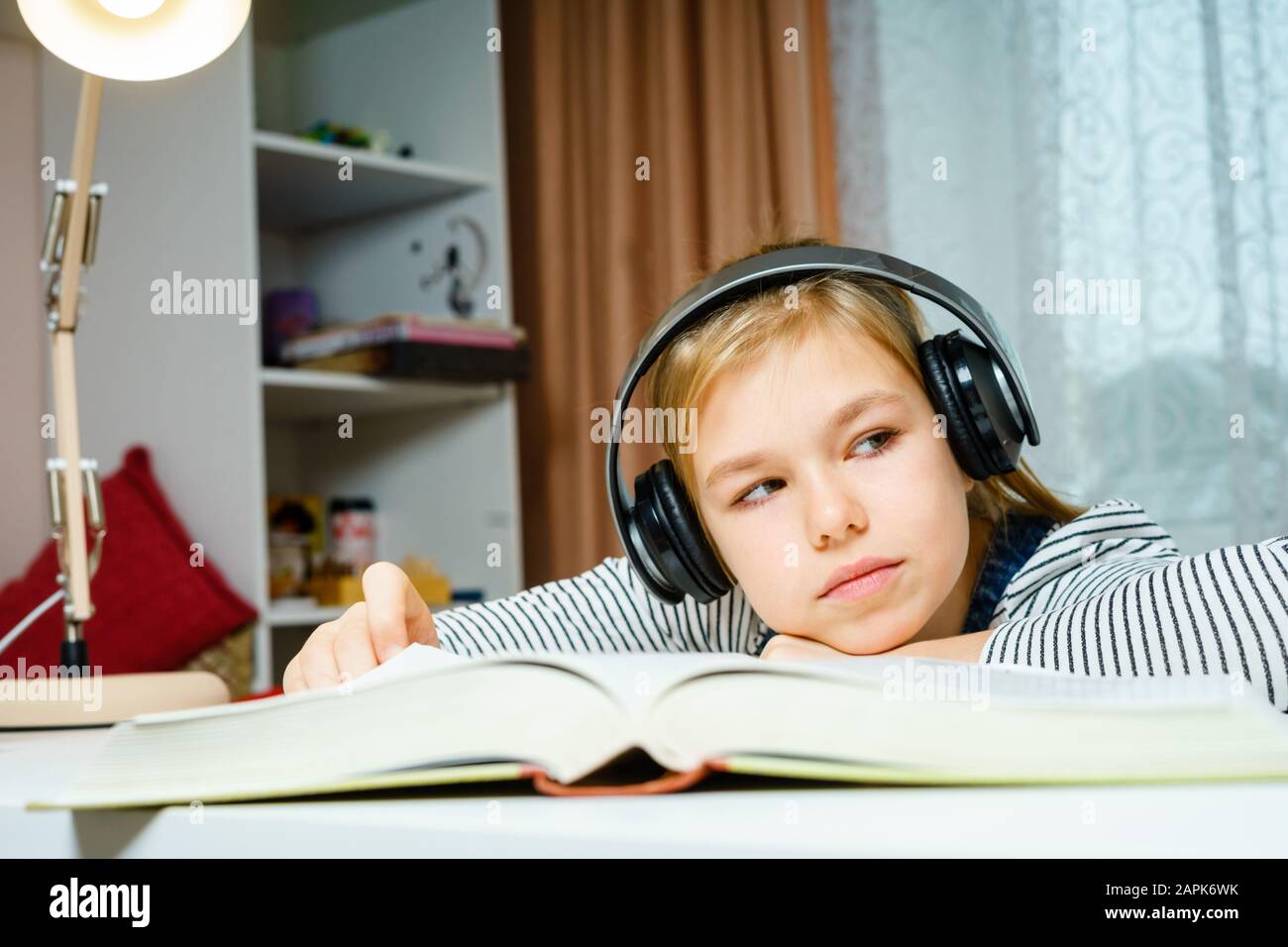 Teenage girl listening music and doing school homework, learning ...