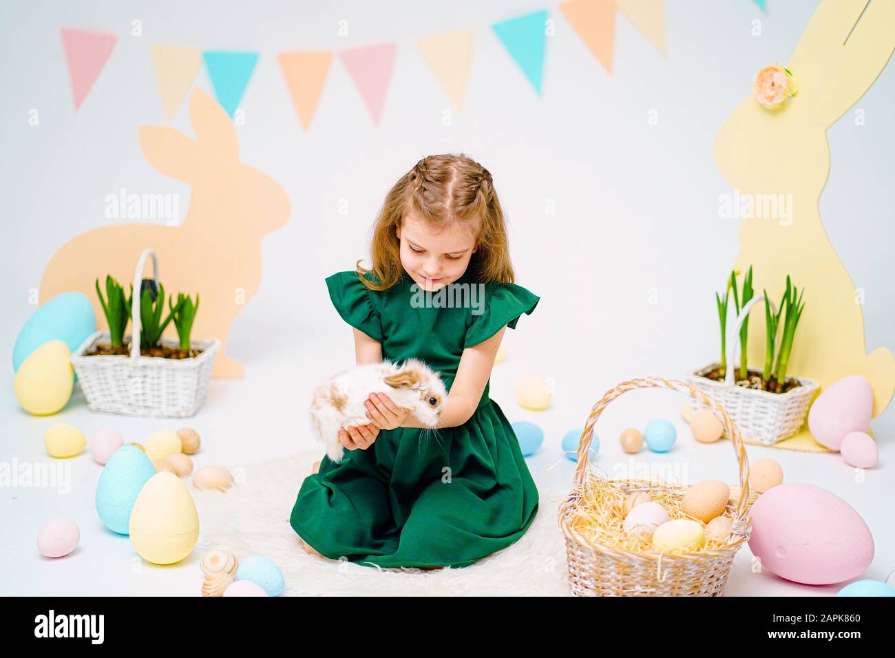 Little girl in green dress with the rabbit. Easter Bunny. Spring photo ...