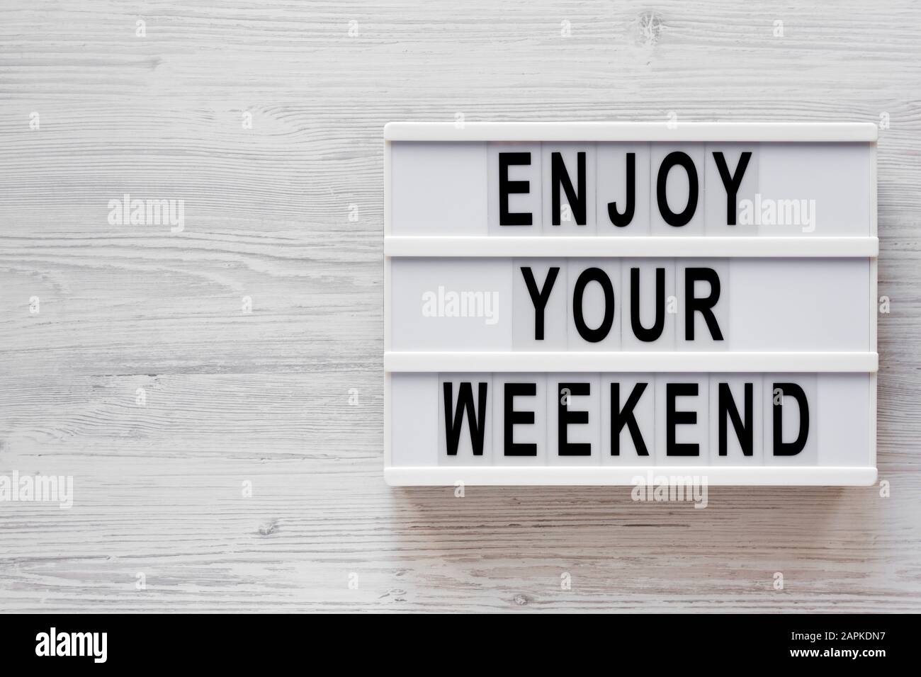 'Enjoy your weekend' words on a modern board on a white wooden ...