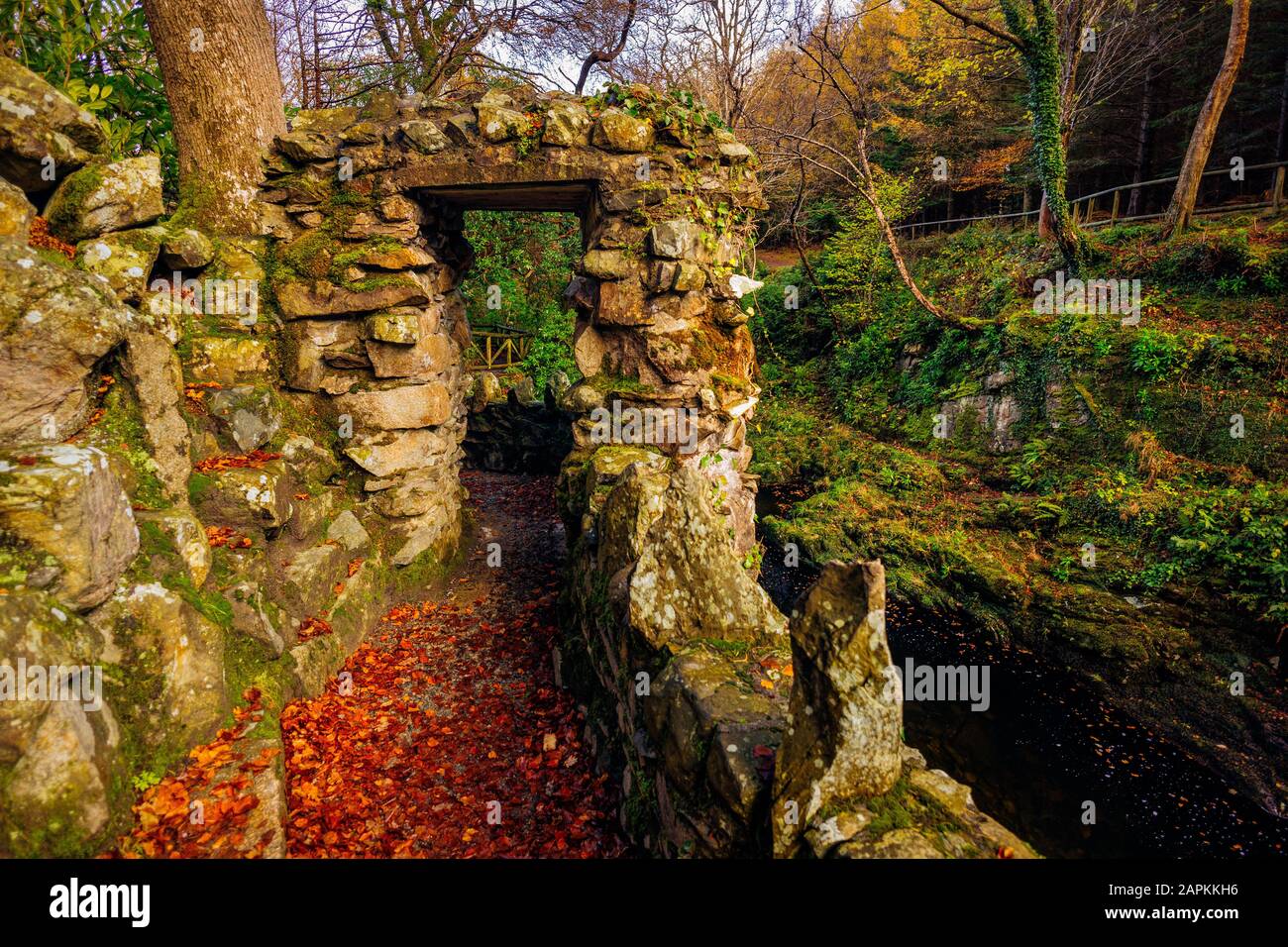 Stone gate of old pathway with river below and green mossy rocks in ...