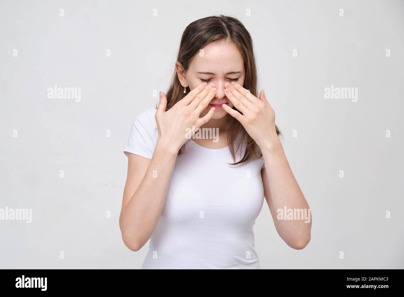 holding his hands by his nose. The concept of sinusitis and snot Stock ...