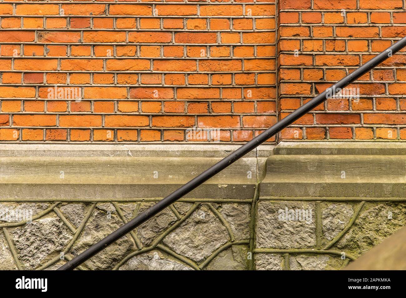 Wide shot of a metal stick across a textured concrete and brick wall ...