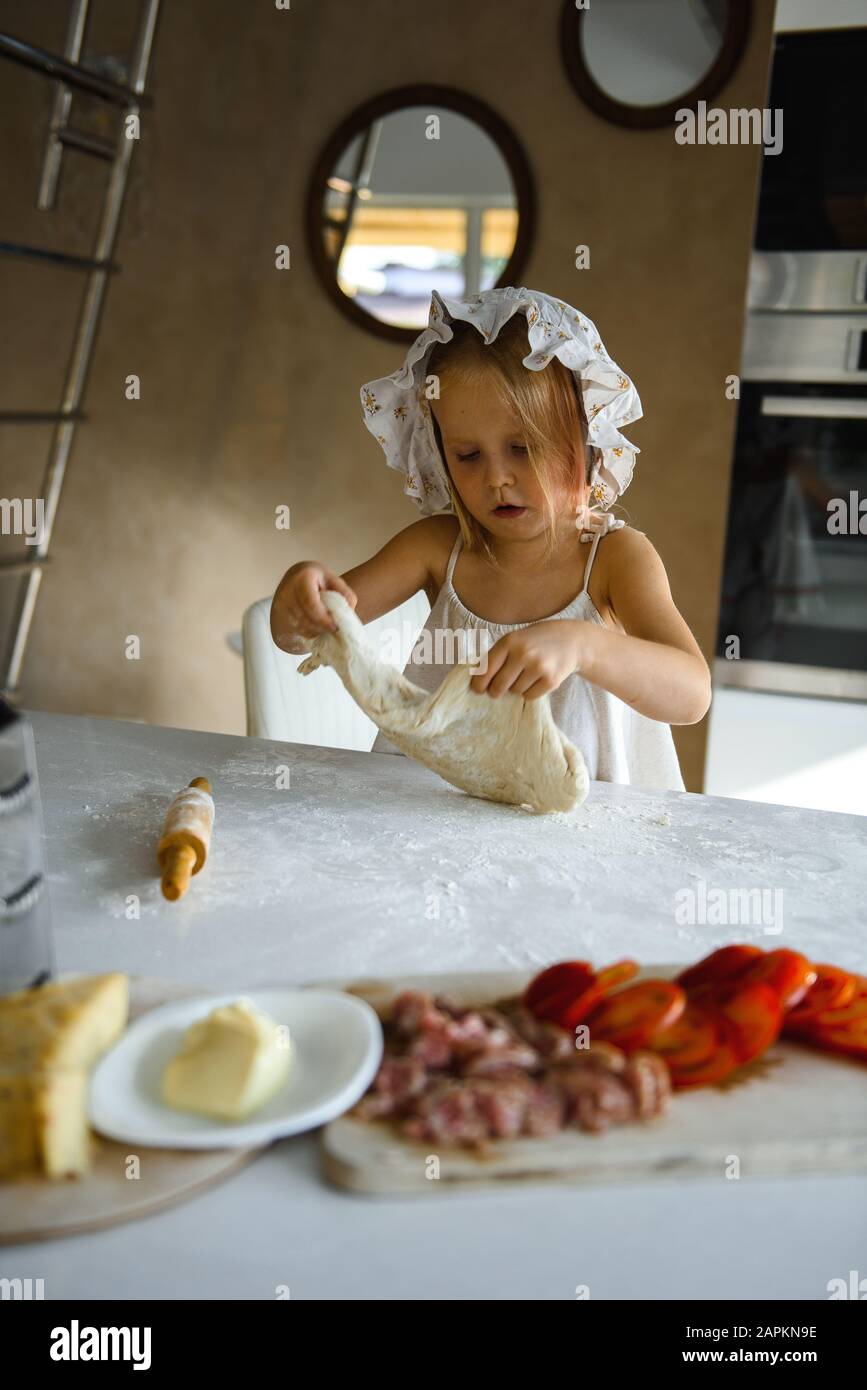 Little girl cooking pizza in the kitchen Stock Photo - Alamy