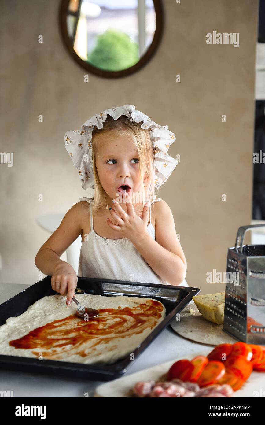 Little girl cooking pizza in the kitchen Stock Photo - Alamy